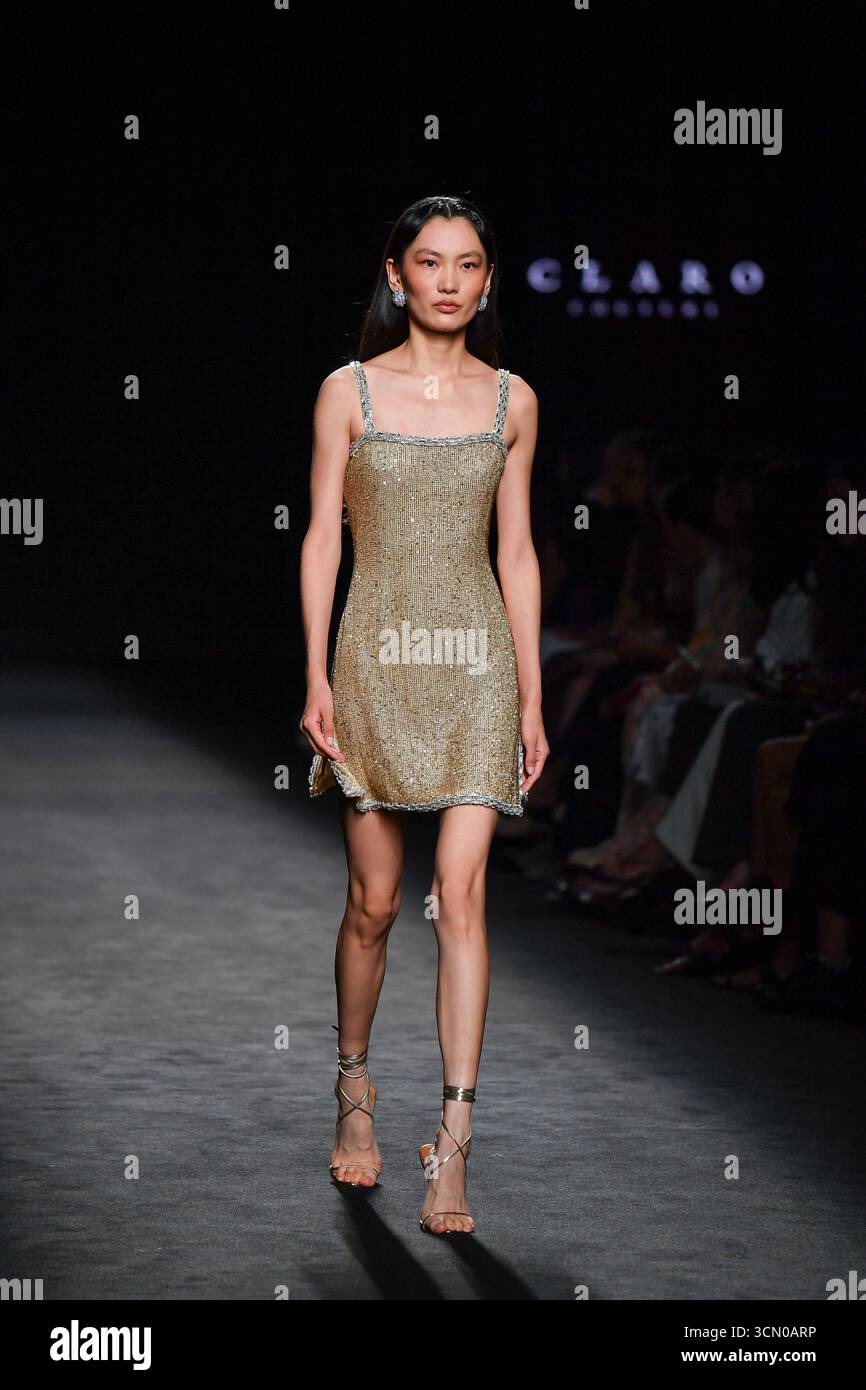 A model walks the runway wearing a design by Claro Couture during ...