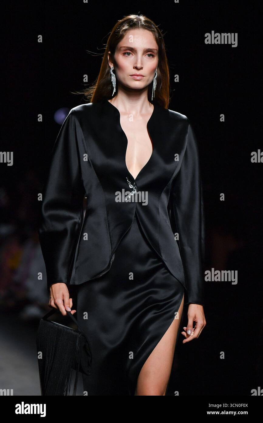 A model walks the runway wearing a design by Claro Couture during ...