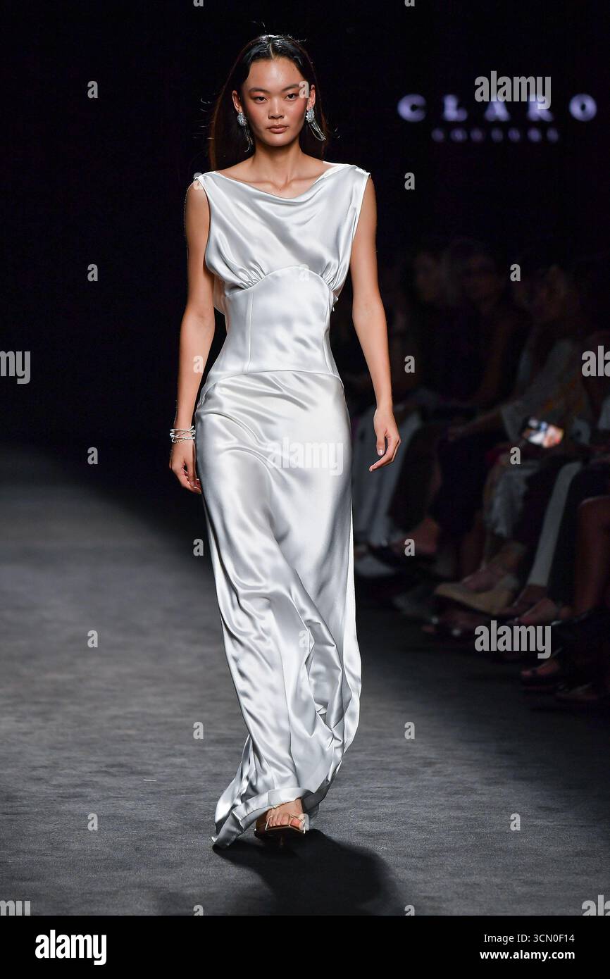 A model walks the runway wearing a design by Claro Couture during ...
