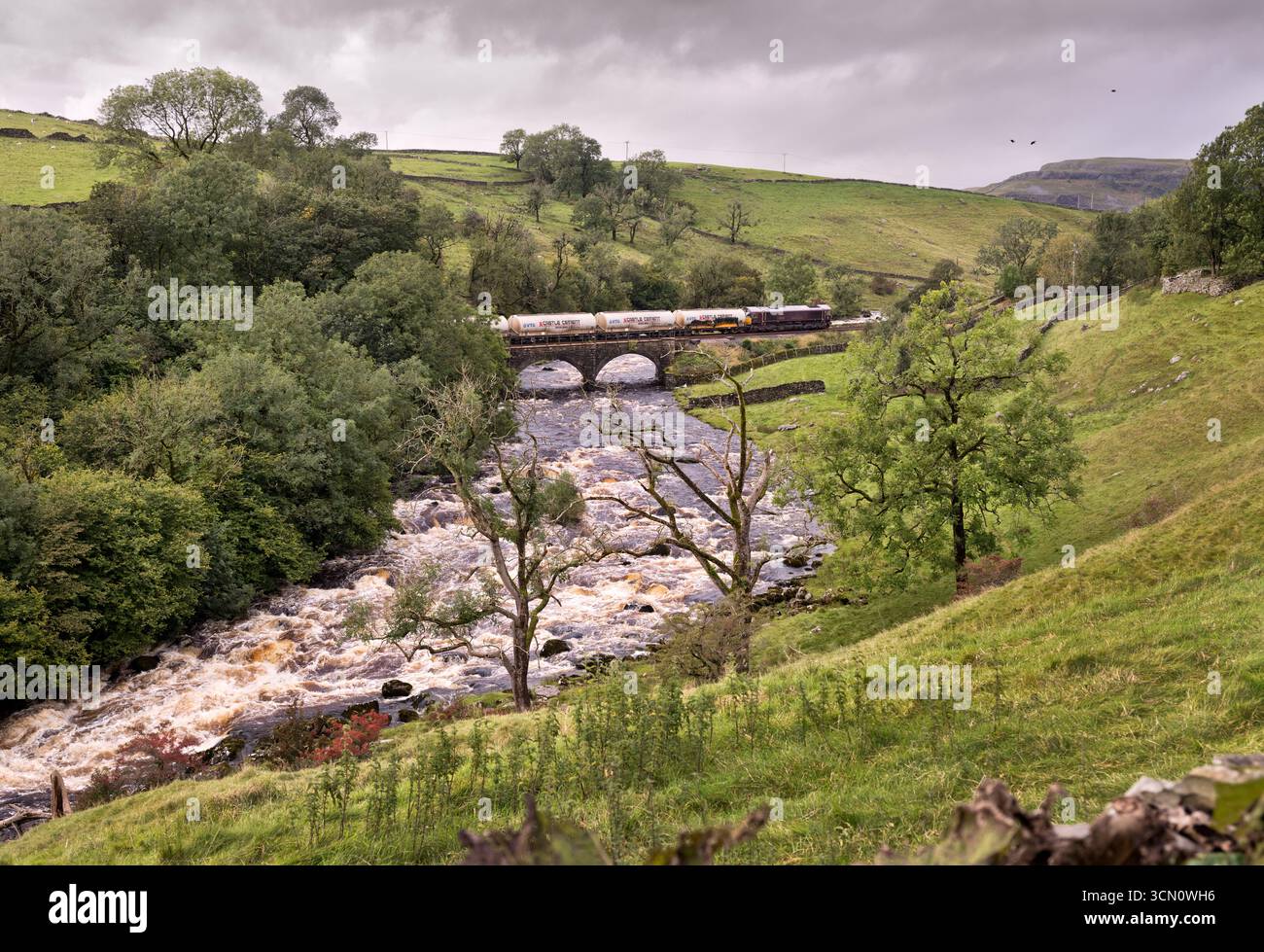 The River Ribble in full spate after heavy rain, as the cement train ...