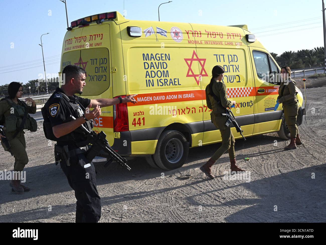 Israeli police and soldiers walk beside an Magen David Adom ambulance ...