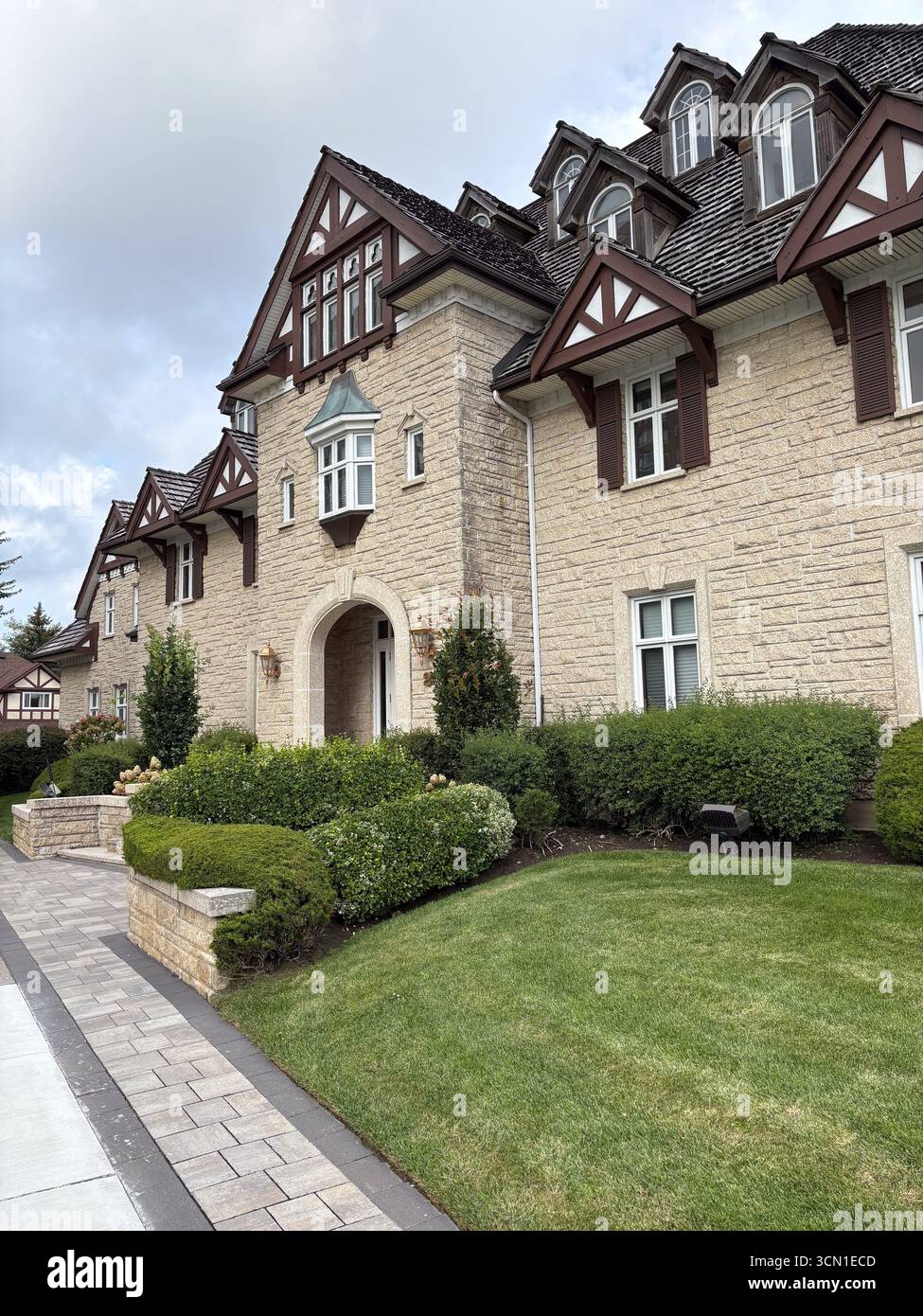 Large stone house with intricate gables, dark timber accents, and ...