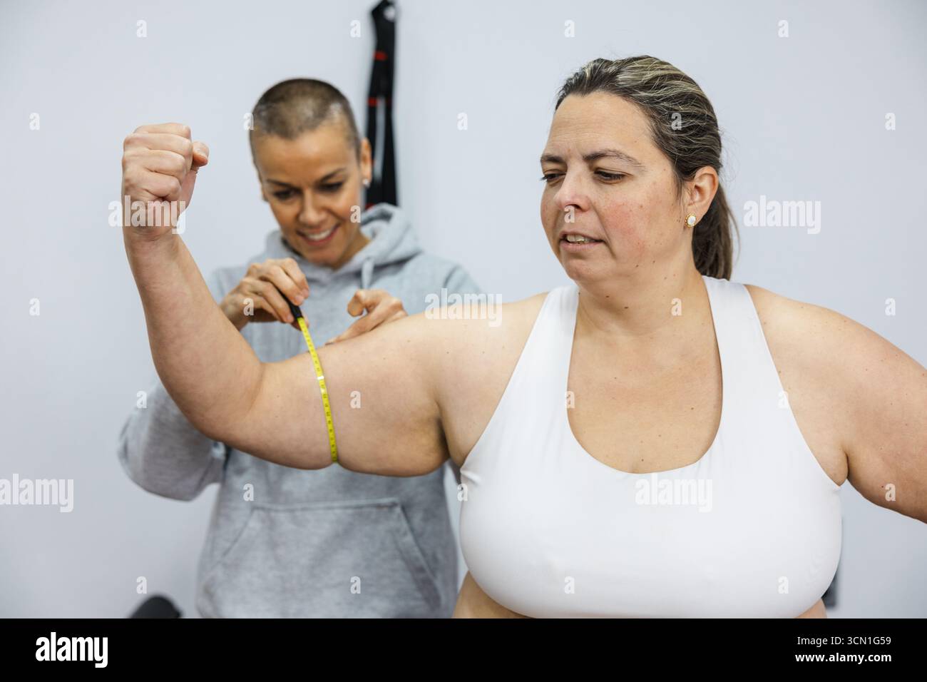 Nutritionist measuring arm of overweight woman for weight loss program ...