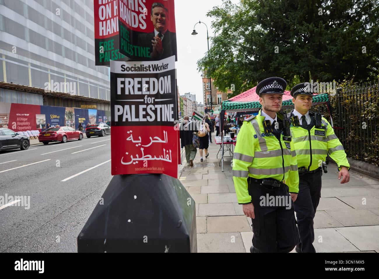 Metropolitan police officers walking passed pro palestine signs Stock ...