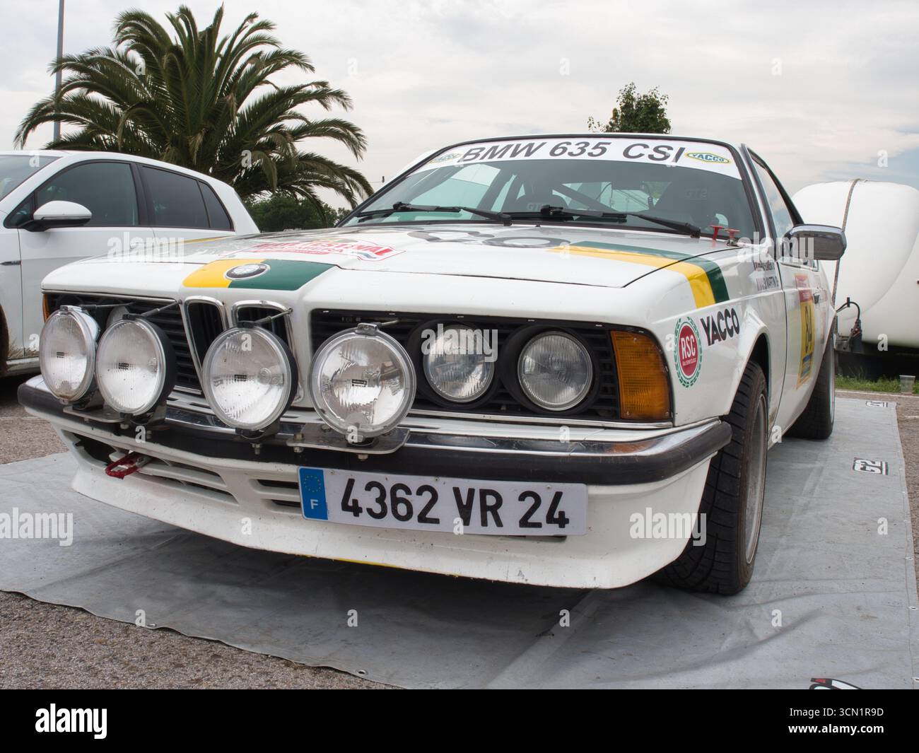 Classic BMW Race Car at a Paddock - A vintage white and yellow BMW 635 ...