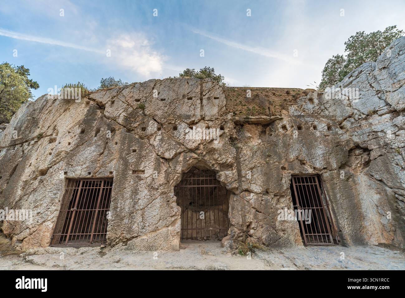 Ancient rock-cut chambers known as the Prison of Socrates on the slopes ...