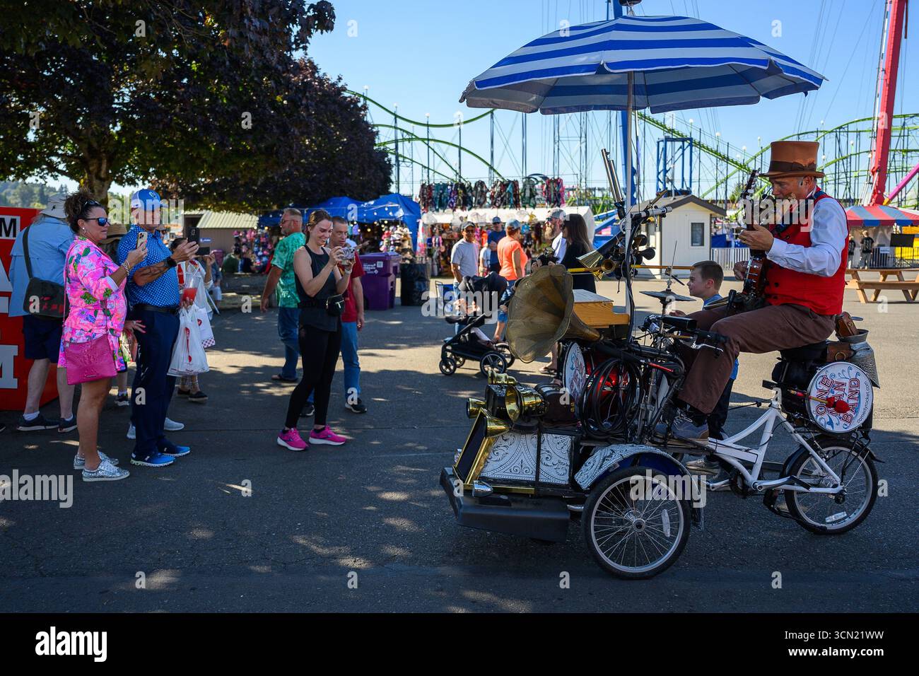 Fair attendees look on during a performance by One Man Band performer ...