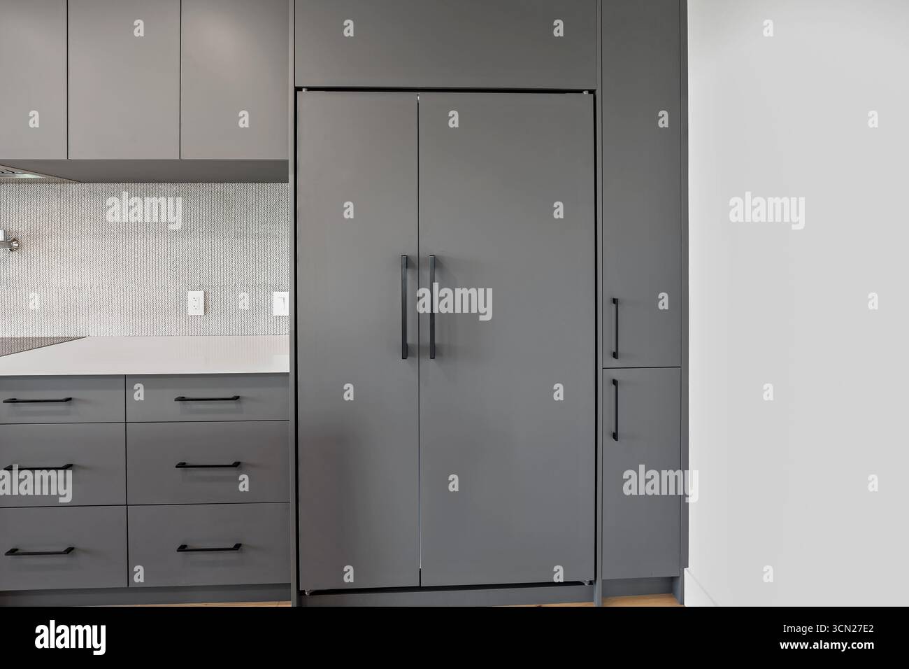 Kitchen with a grey refrigerator and cabinets. The refrigerator has two ...