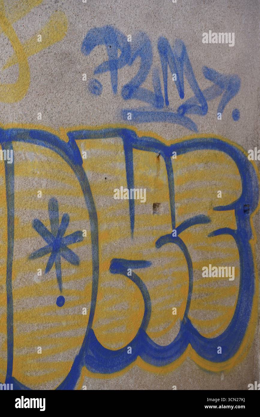 Vibrant Blue-Outlined Yellow Graffiti Wall Art on Rough Concrete ...