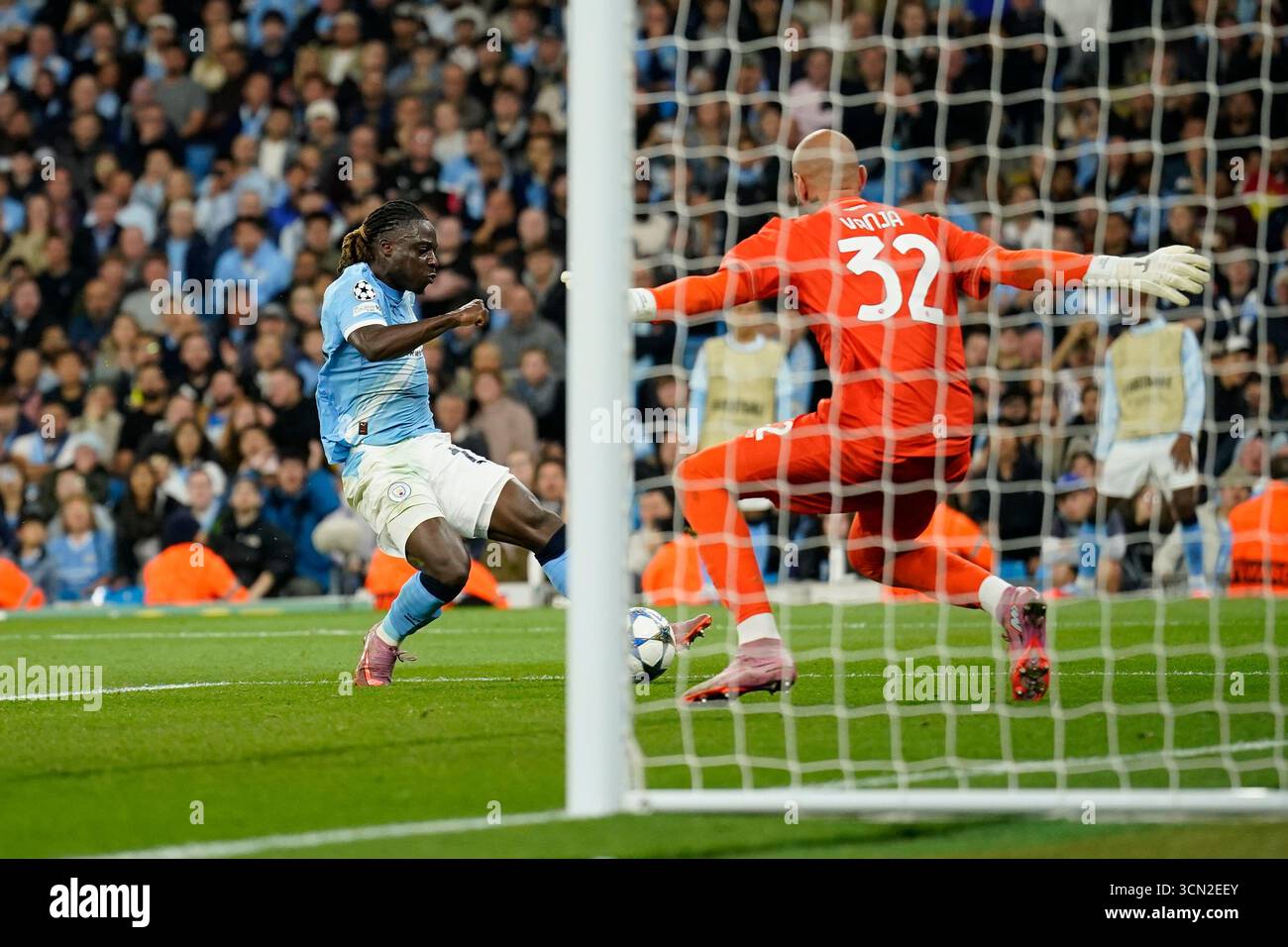 Manchester City's Jeremy Doku, left, scores his side's second goal past ...