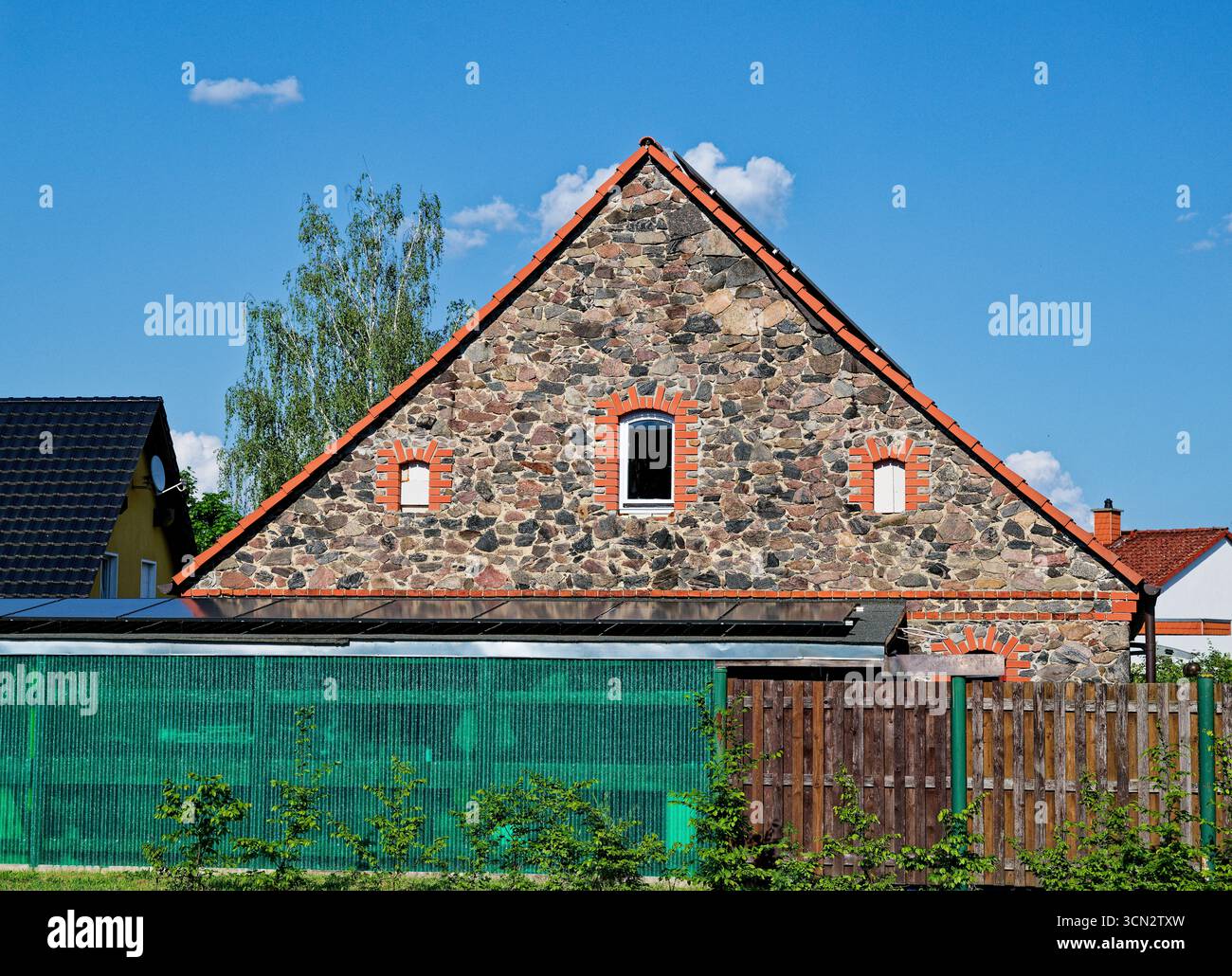 A two story house built from large stone blocks set in mortar shows a ...