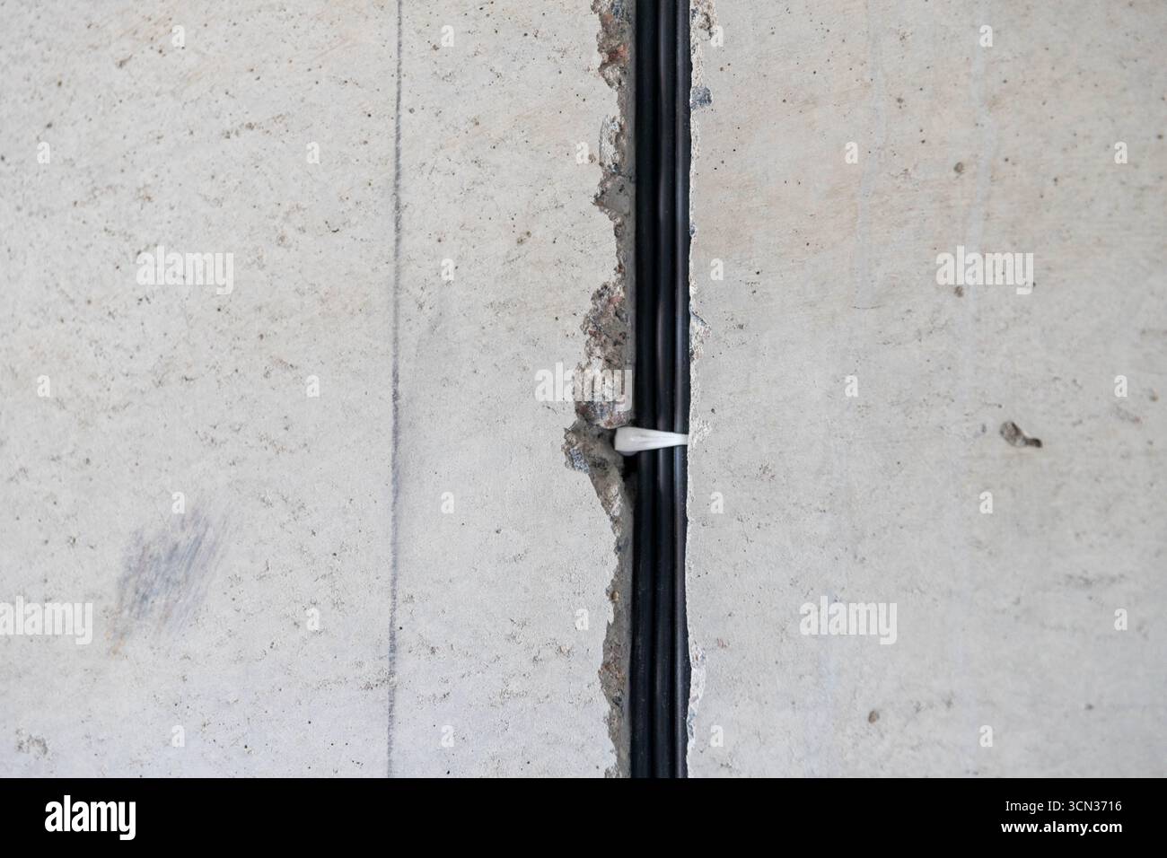 electrical cable is laid in protective corrugation in groove in wall ...