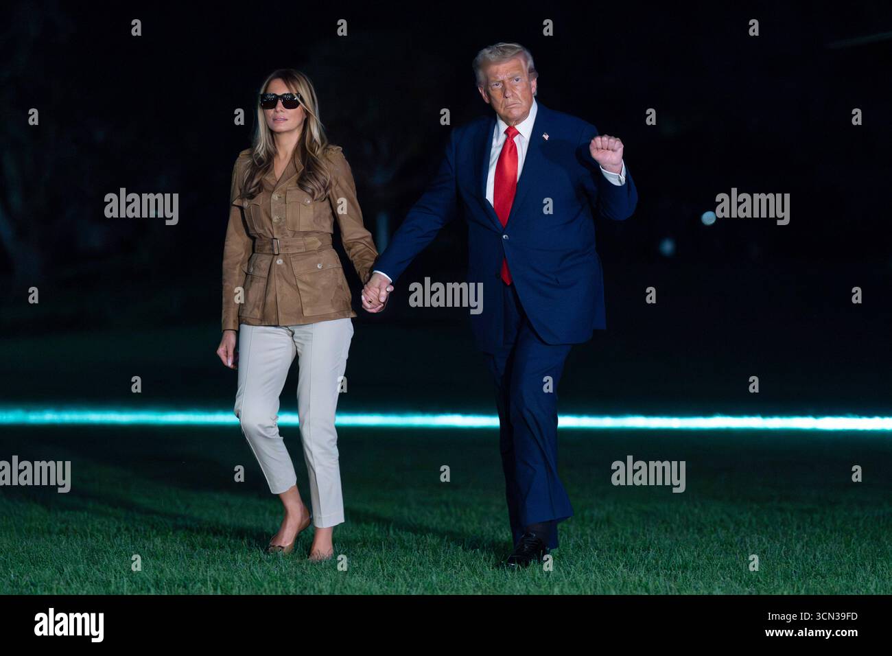 President Donald Trump holds hands with first lady Melania Trump as ...