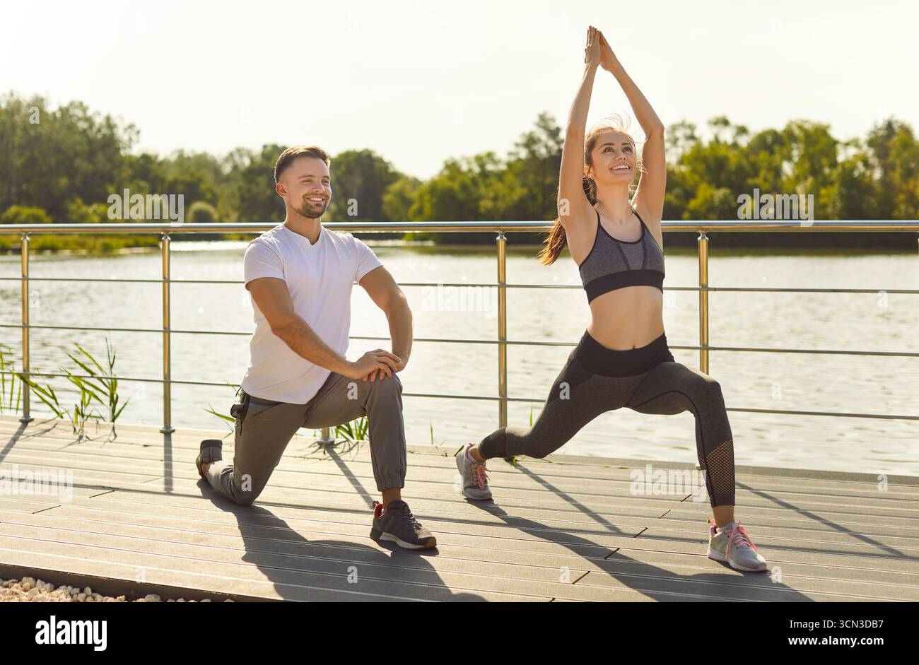 Sunny outdoor sporty yogi couple near water, friends, family people ...