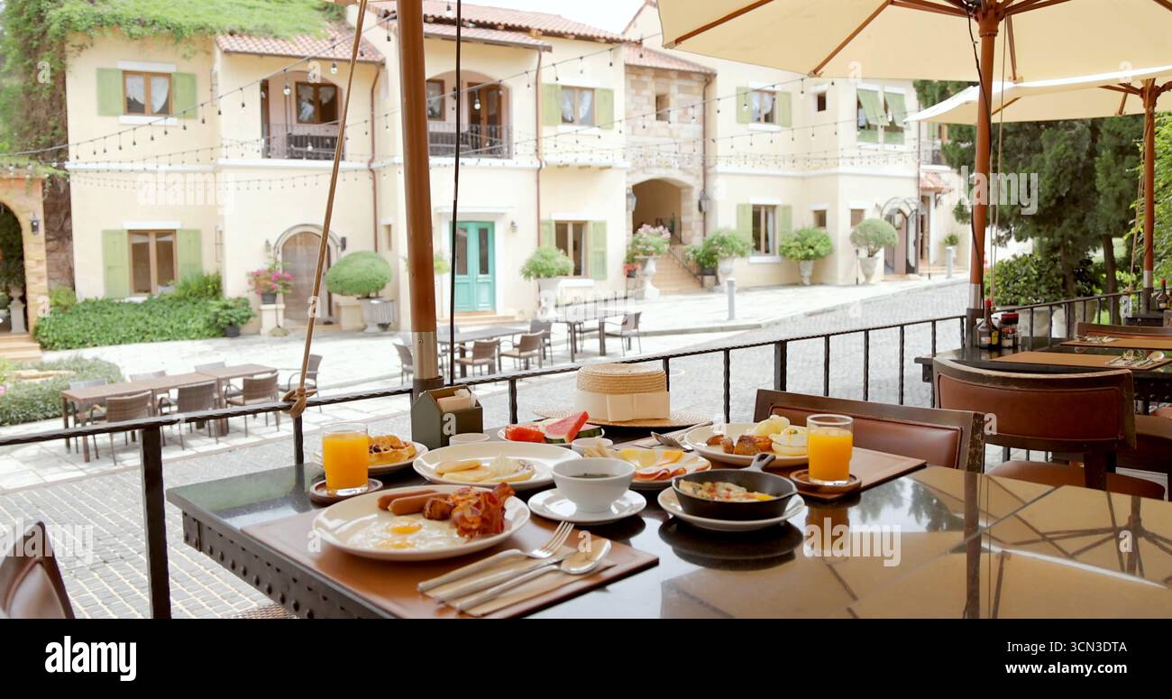 Mediterranean breakfast on outdoor cafe terrace, village architecture ...