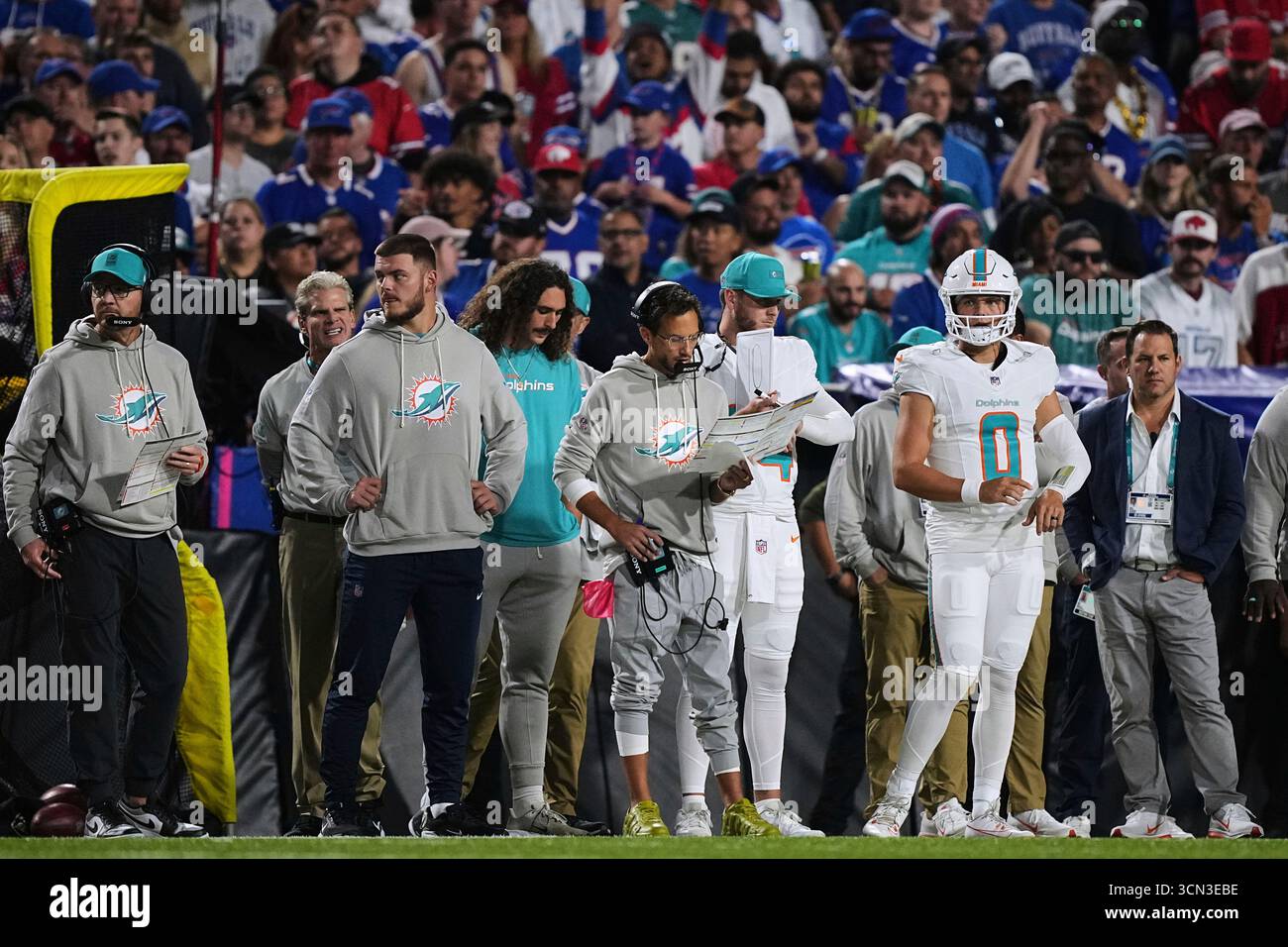 Miami Dolphins head coach Mike McDaniel, center, looks at a play sheet ...