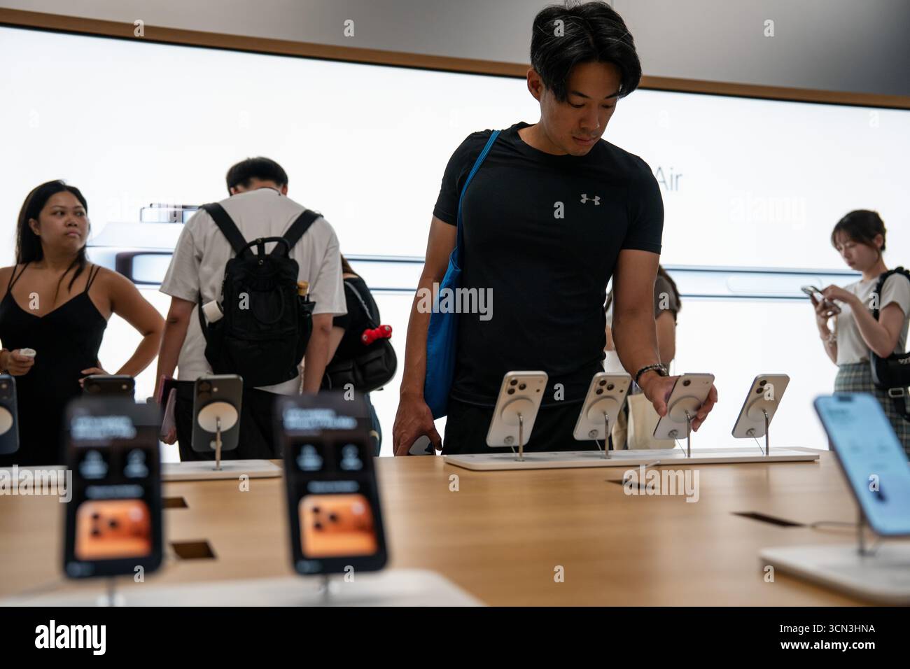 A man looking at iPhone on display inside the Apple Store in Causeway ...