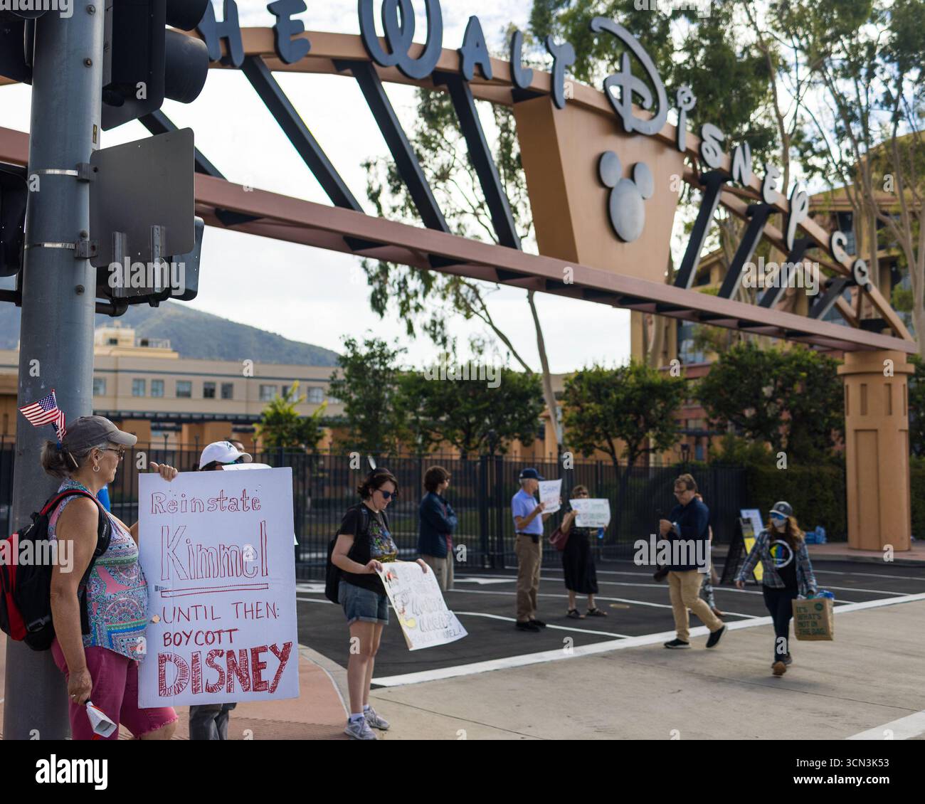 Protesters hold placards outside the entrance of Walt Disney Studios ...