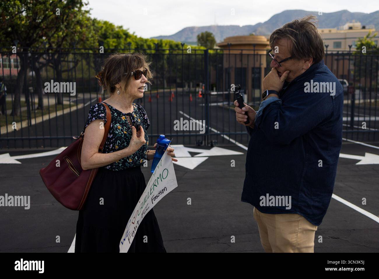 A protester holding a placard speaks during an interview in front of ...