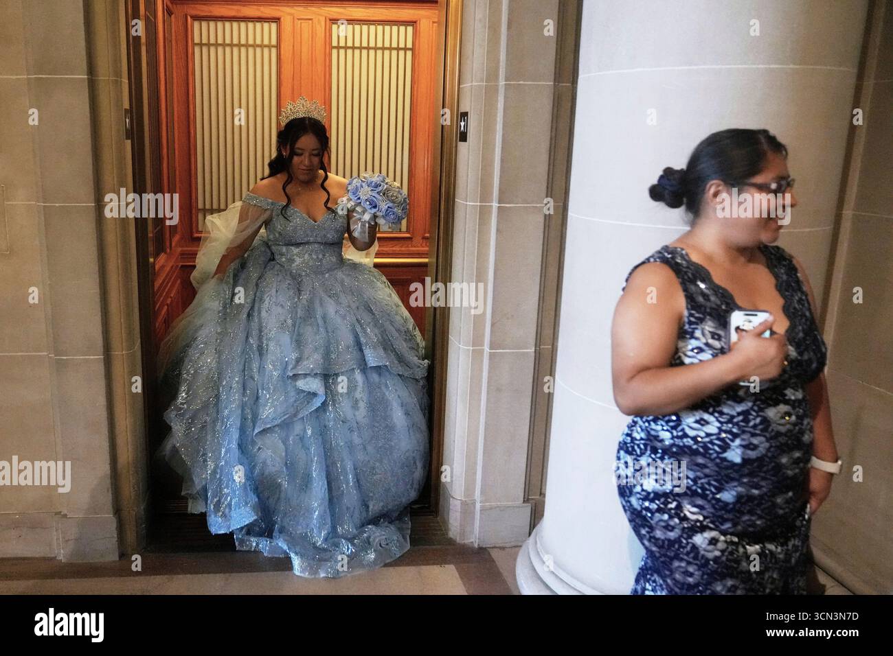 Abbie Gonzalez exits the elevator behind her mother Anna Gonzalez after her quinceañera portrait ...