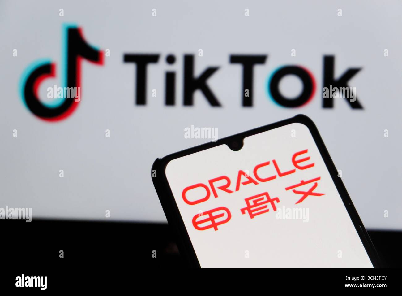 In this photo illustration, an ORACLE logo is displayed on a smartphone with a TikTok logo in ...