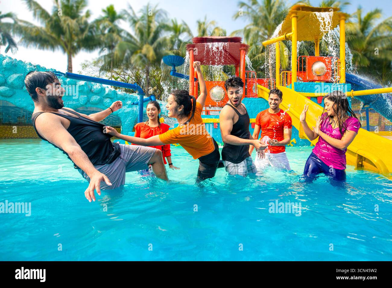 A Diverse Group of Friends Laughing and Playing in a Water Park Pool ...