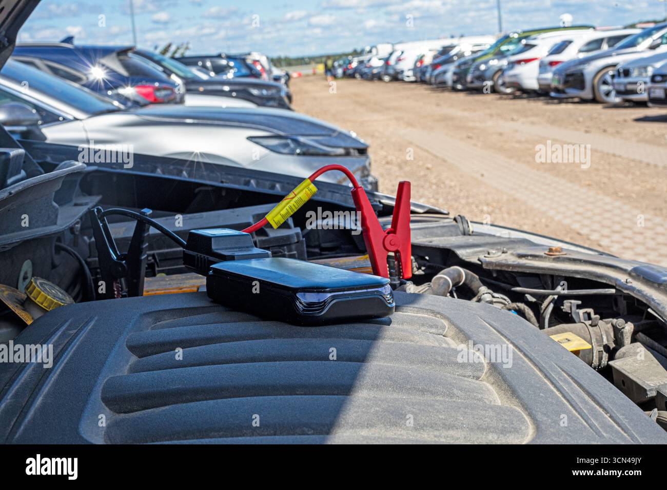 Jumpstart a dead car battery using a power bank in the parking lot ...