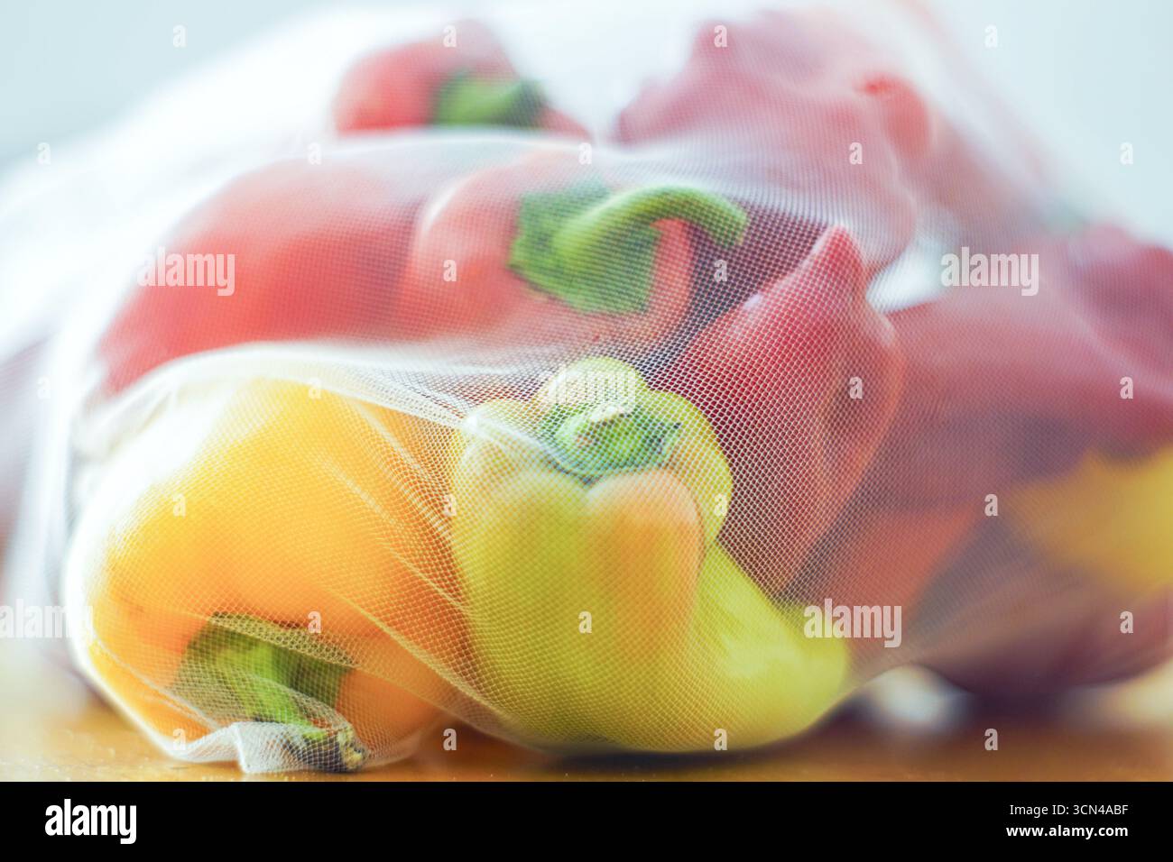 Colorful paprika stored in net pouch. Vegetables produce wrapped in ...