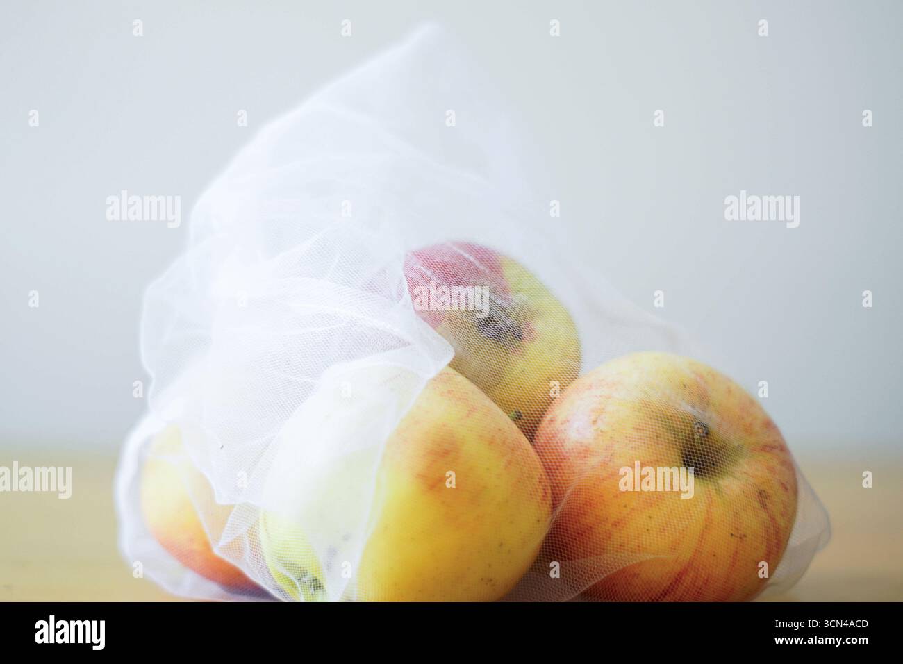 Fresh organic apples in eco-friendly mesh storage bag. Sustainable food ...