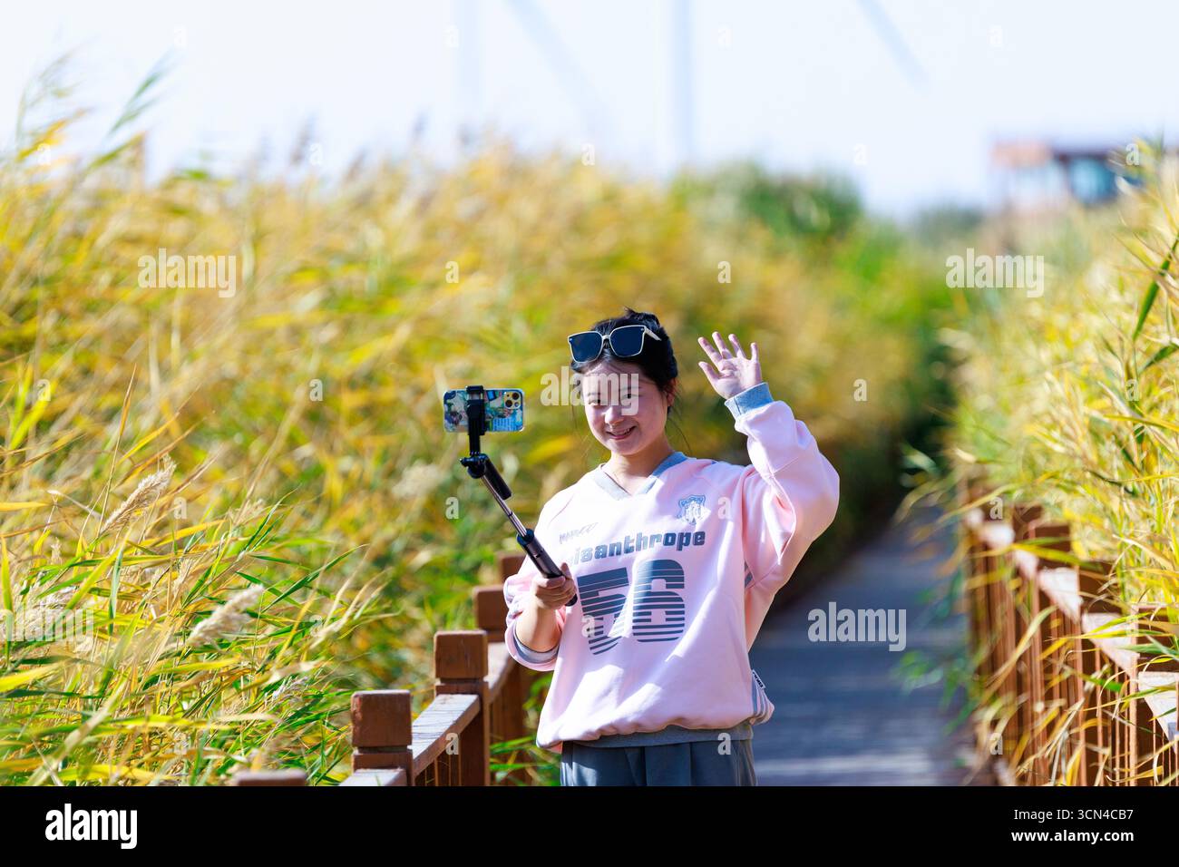 Tourists admire autumn scenery at a wetland park in Urumqi City ...