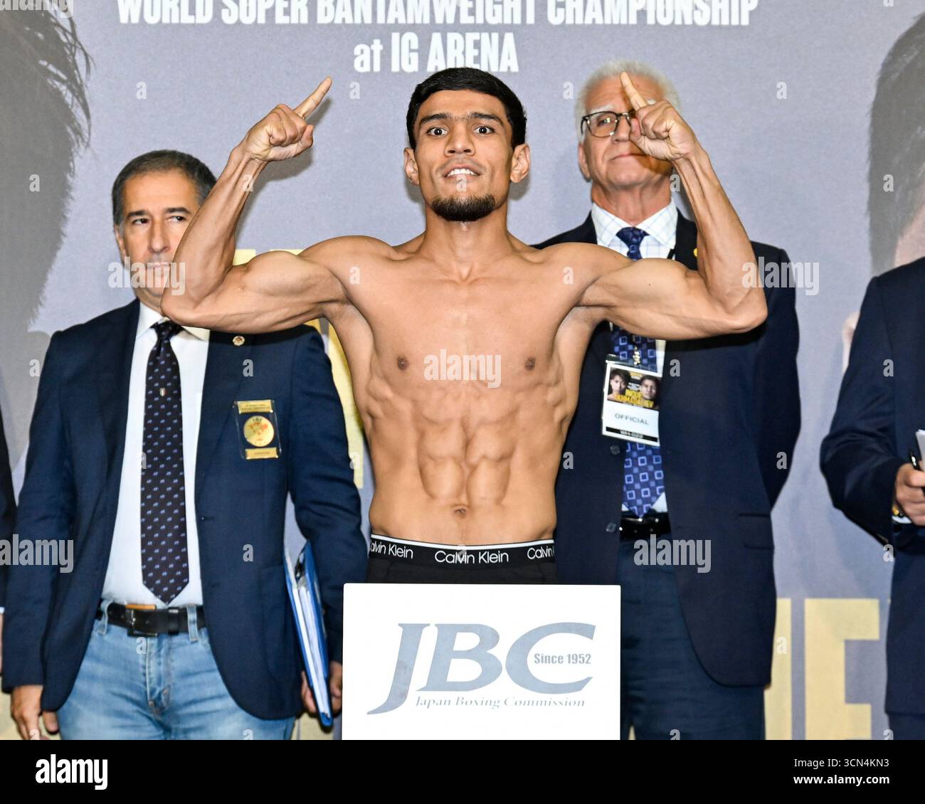 Challenger Uzbekistan's Murodjon Akhmadaliev poses on the scale during the official weigh-in for ...