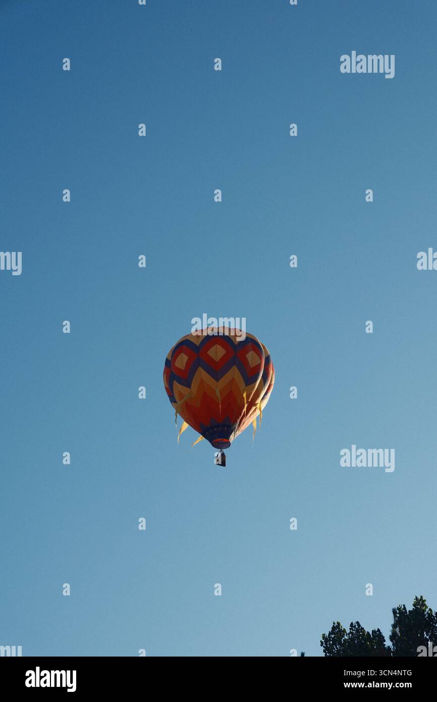 Colorful hot air balloon soaring in the clear blue sky Stock Photo - Alamy
