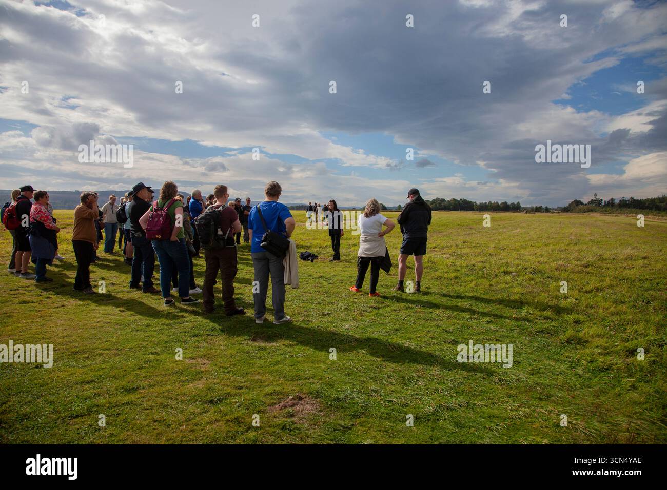 Tourists visit the Culloden Battlefield memorial. with a guide ...