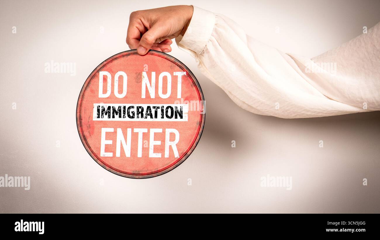 Hand holding red do not enter immigration sign Stock Photo - Alamy