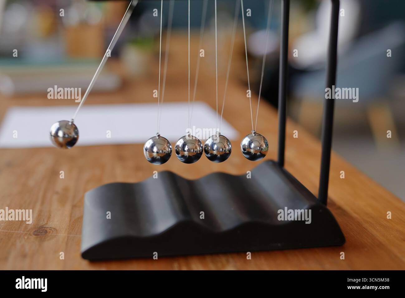 Newtons Cradle Demonstrating Physics Principles on Wooden Table Surface ...
