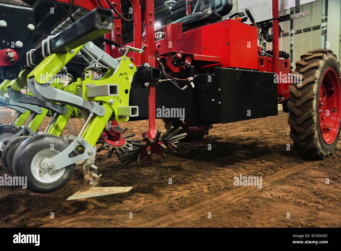 Farm implements, at left, and a battery, are attached to the underside ...