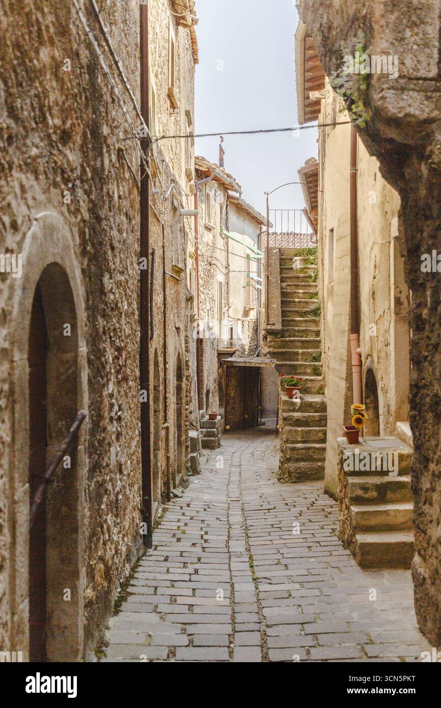 View of a narrow cobblestone street lined with aged stone buildings ...