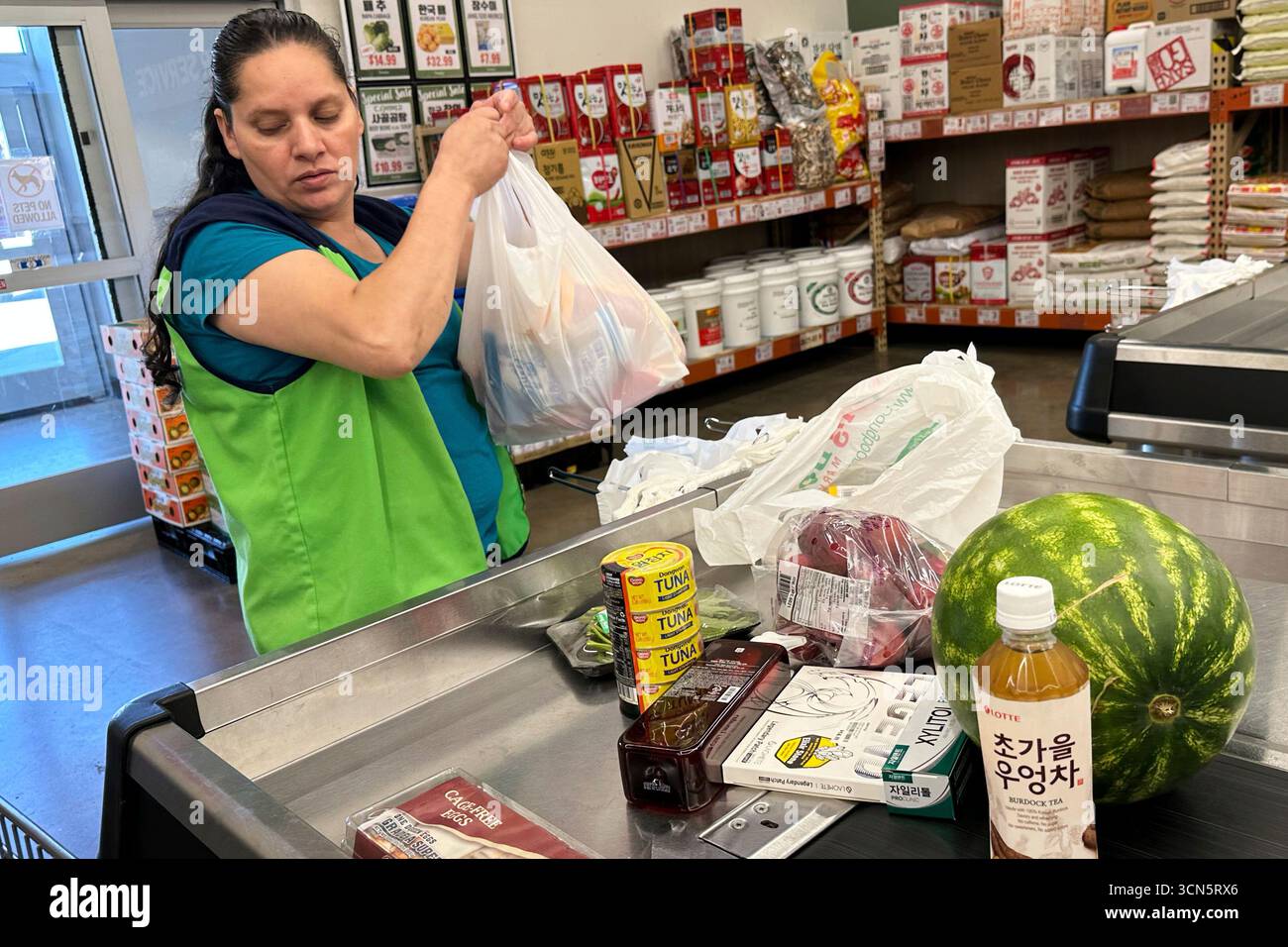 An employee works at a cash register in a grocery store in Schaumburg ...