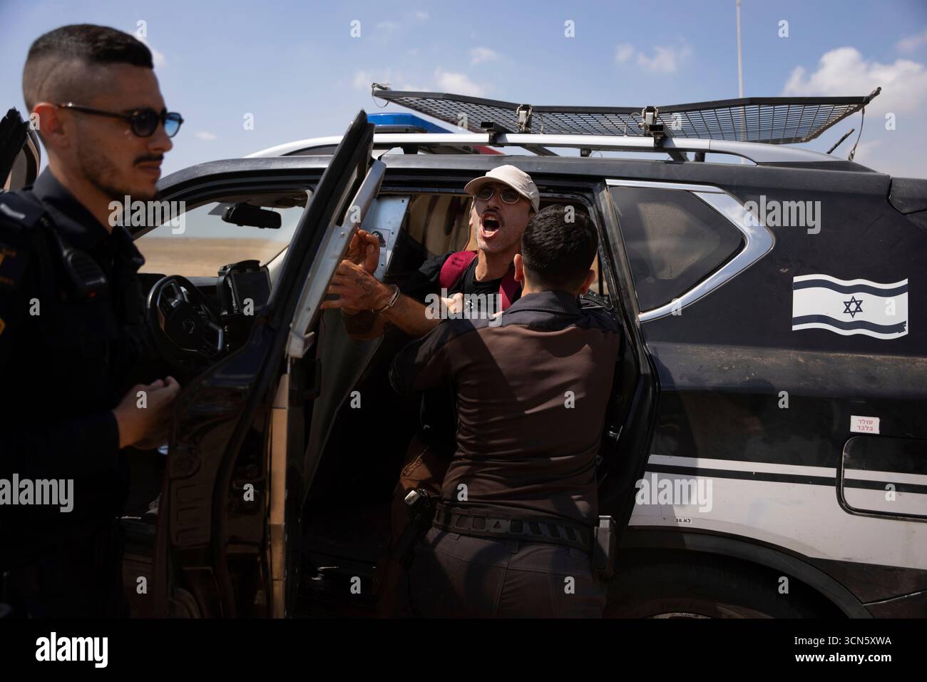Police officers detain an activist during a protest against the war in ...