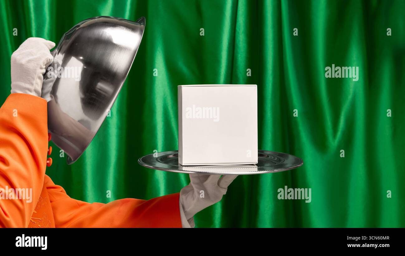 Waiter hand lifting silver cloche to reveal white box on tray against ...