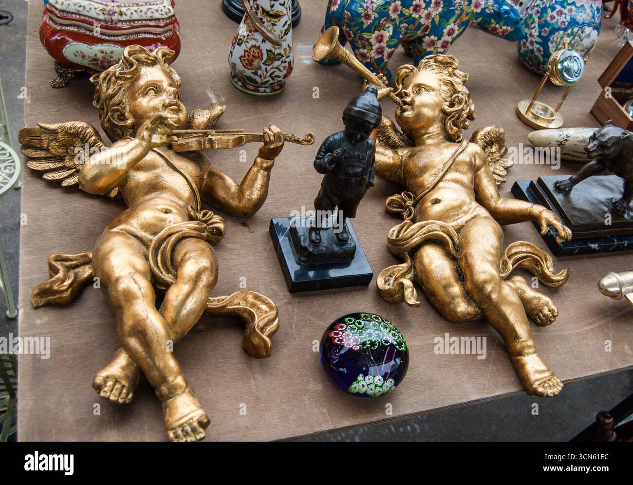 Flea market in Paris, France. Two golden baby angels playing on violin ...