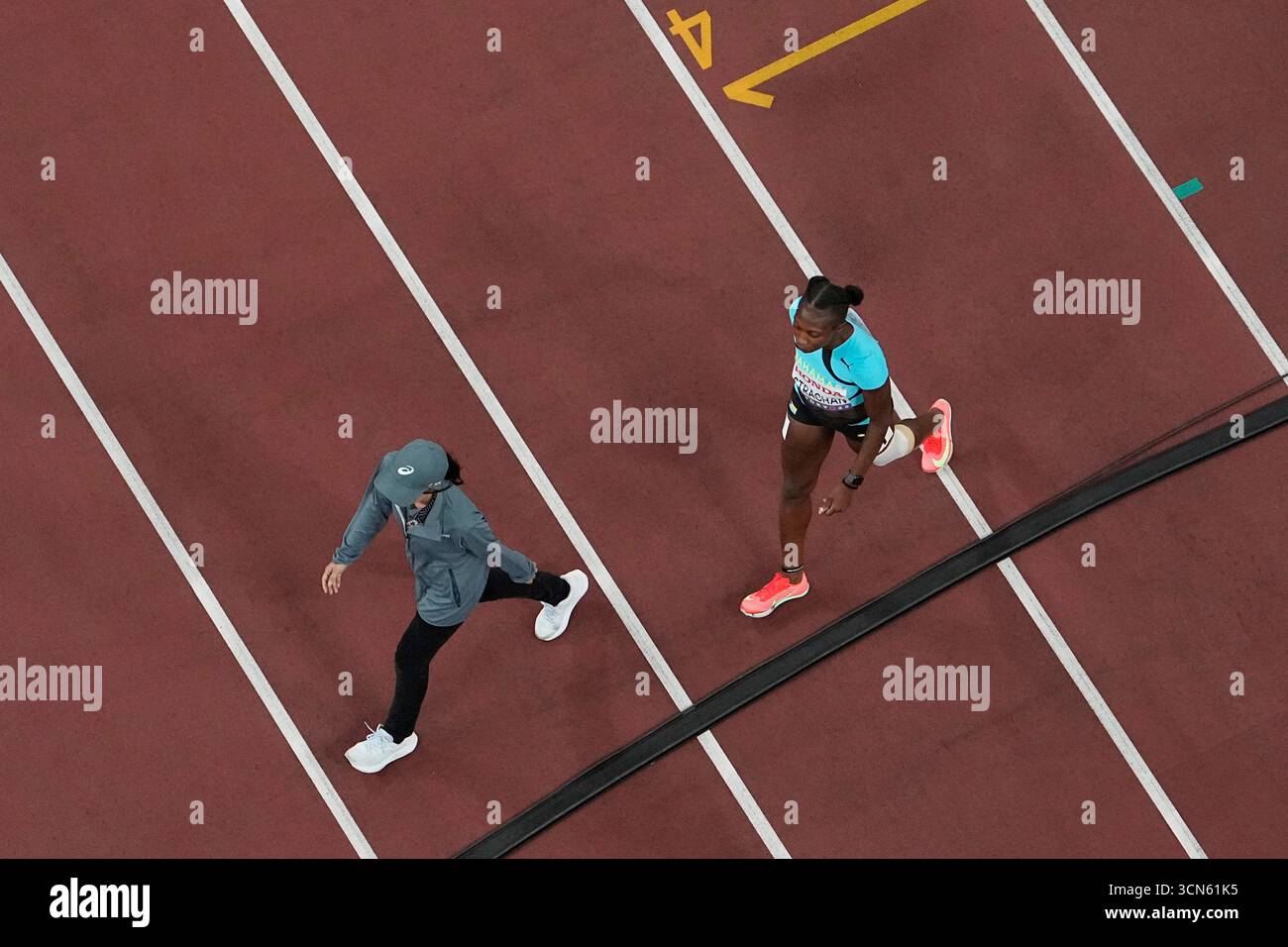 Bahamas' Anthonique Strachan, right, is escorted off the track after a ...