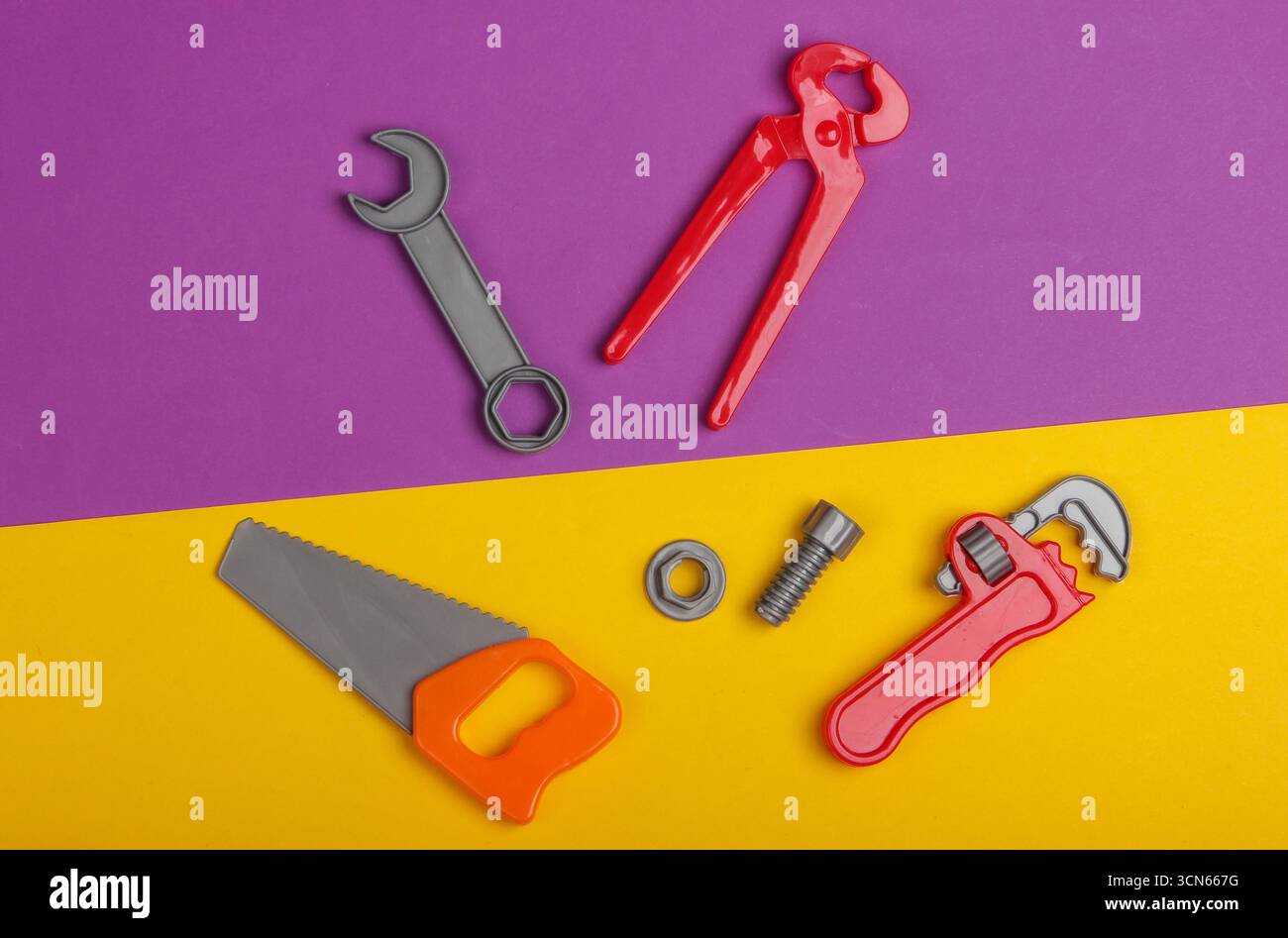 Plastic children`s work tool kit on purple yellow background. Toys. Top ...