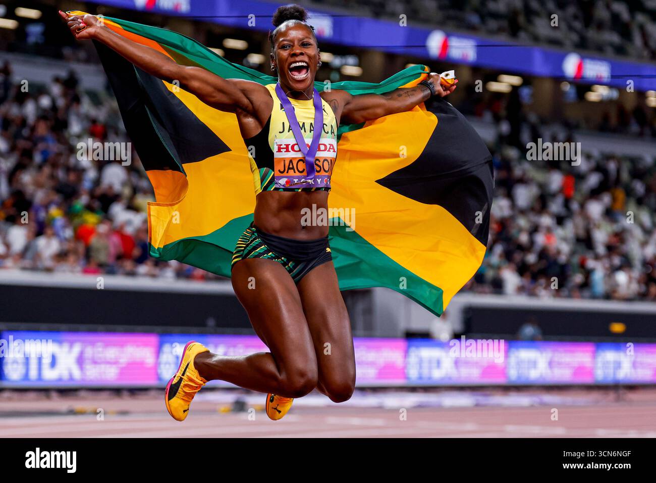 third Shericka Jackson of Jamaica celebrating and holding flag after during the Women's 200 ...