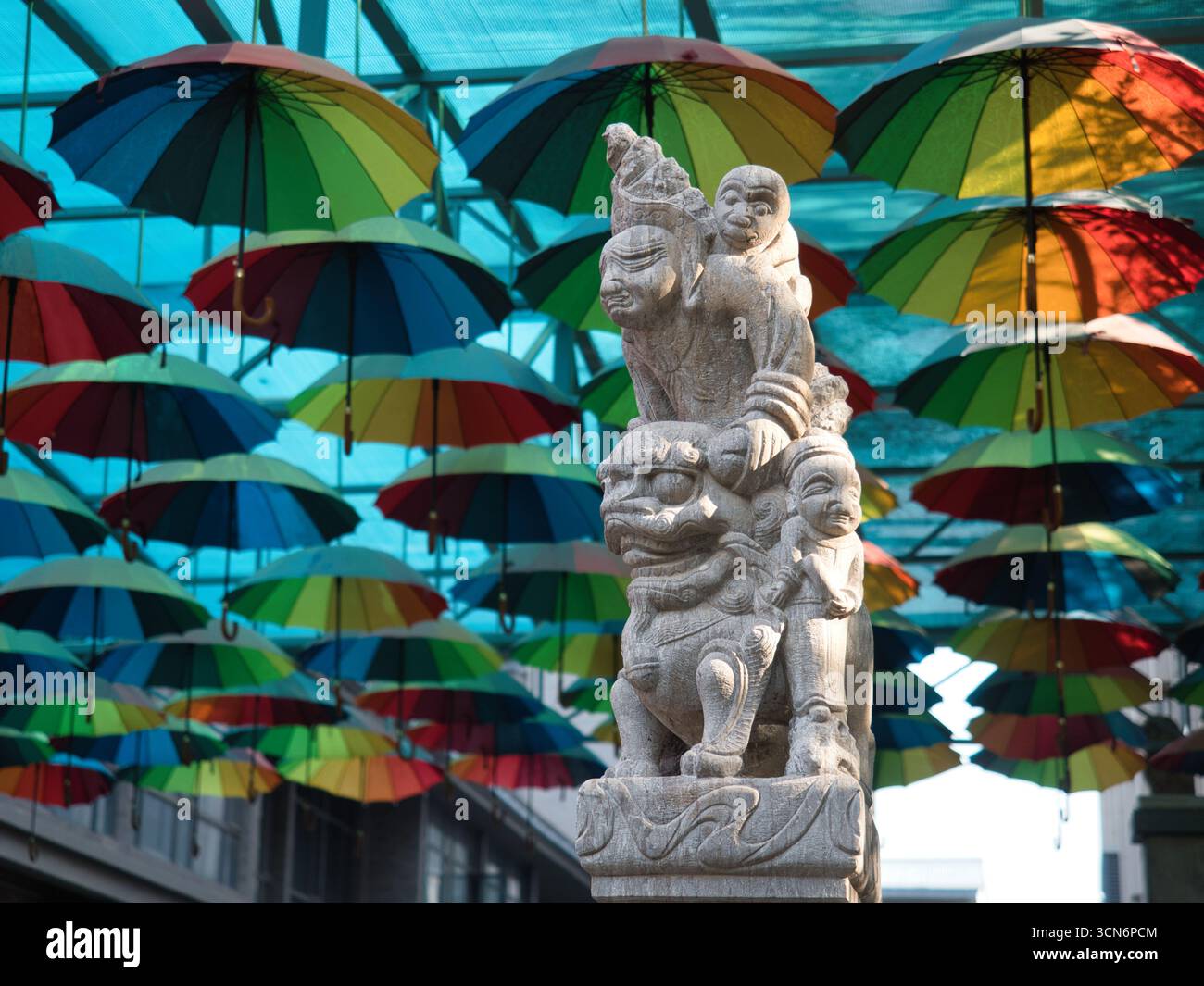Traditional Chinese Statue with Colorful Umbrellas - A detailed stone ...