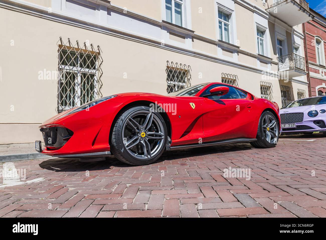 Red Ferrari supercar parked on cobblestone street. Vilnius, Lithuania ...