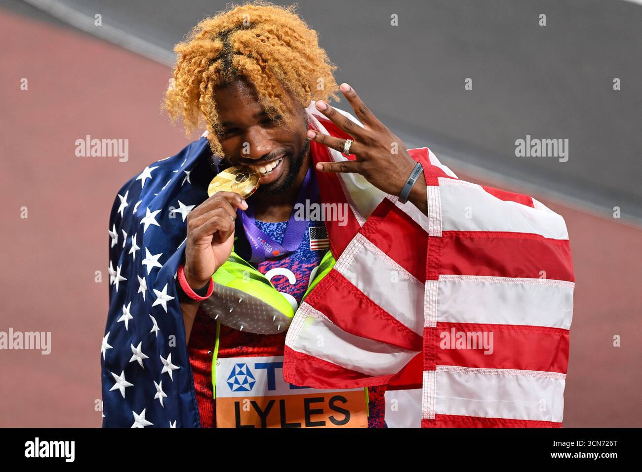 Noah Lyles (United States) biting his gold medal and showing four ...
