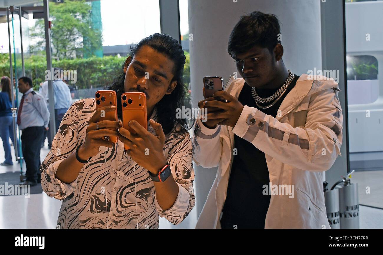 People take photos models of iPhone 17 series kept on display inside ...