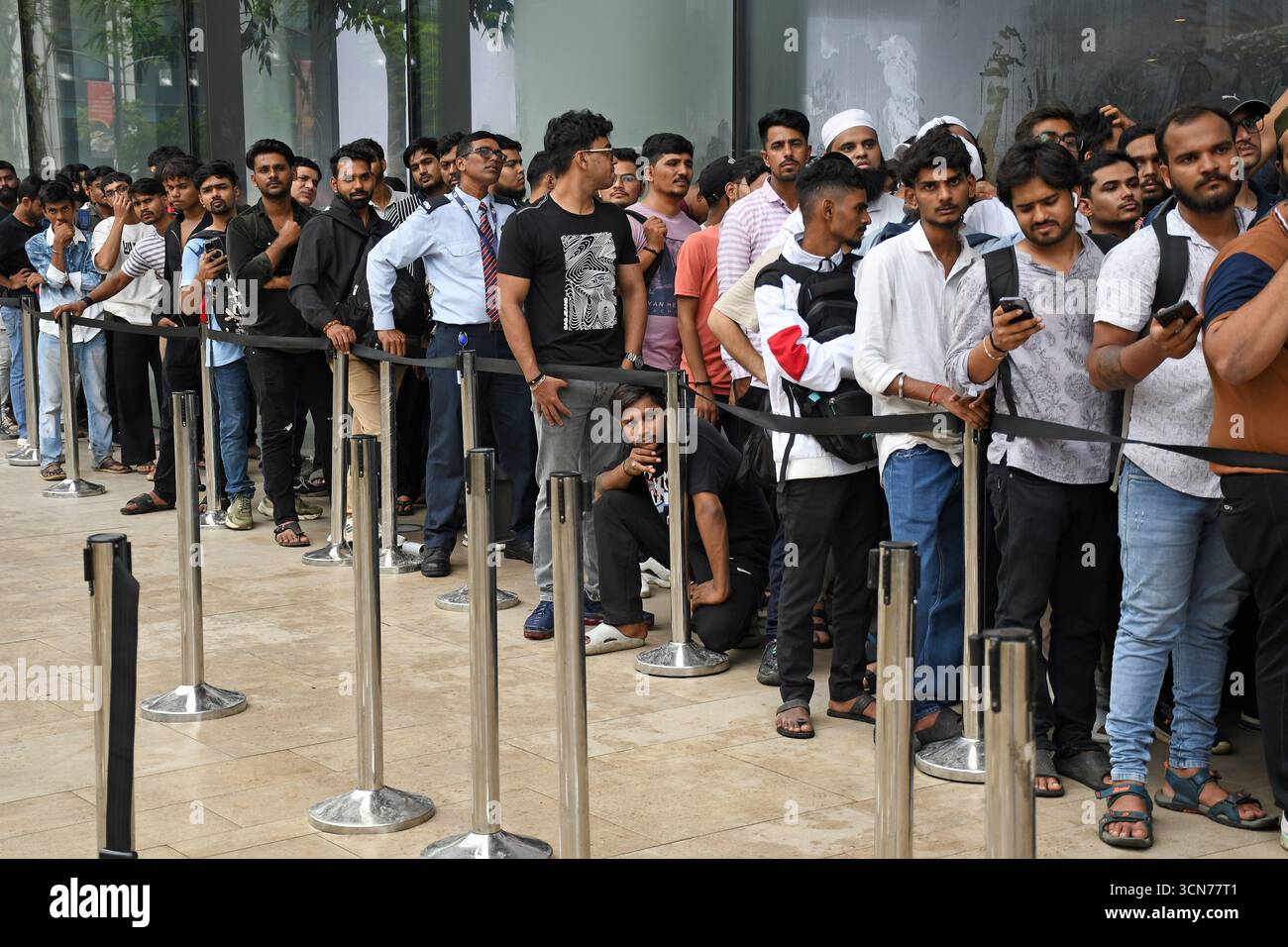 People stand in queue waiting to buy the new iPhone 17 series mobile ...