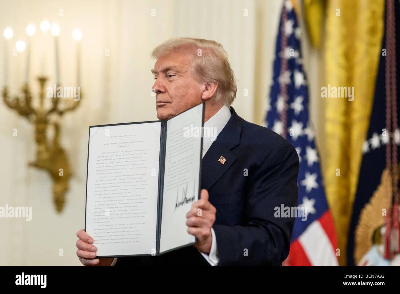 President Donald J. Trump holds up a signed proclamation during a ...